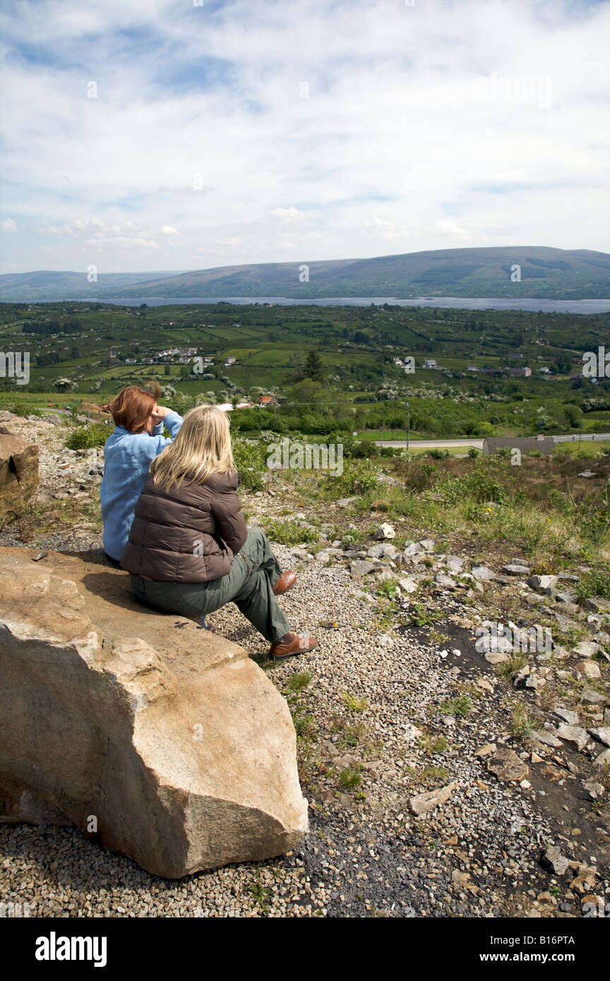 TWO HIKERS REST AT ARIGNA AND OBSERVE THE VIEW OVER COUNTY LEITRIM ...