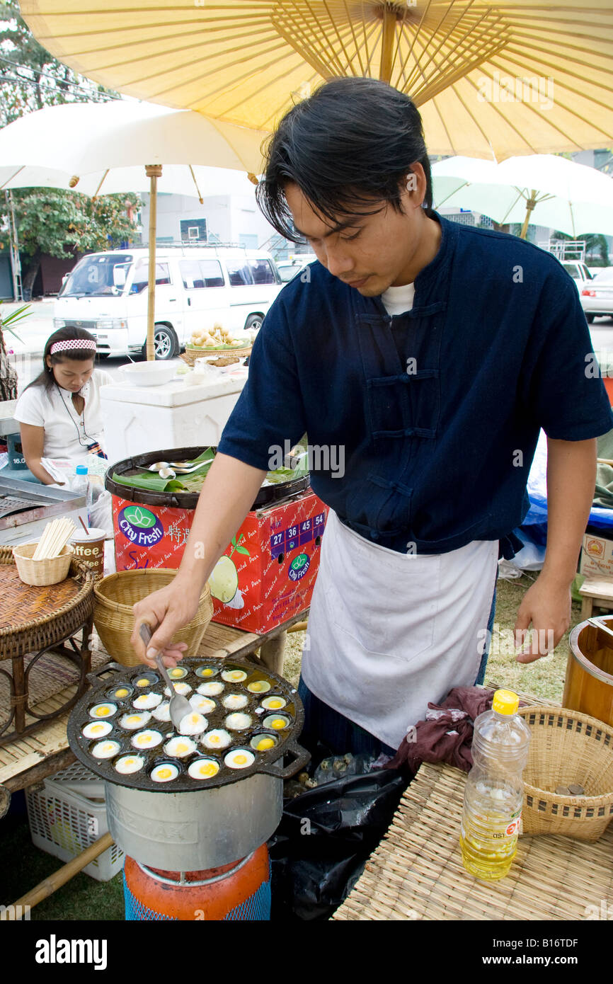 a guy cooking food in his street food stall inside the temple grounds ...
