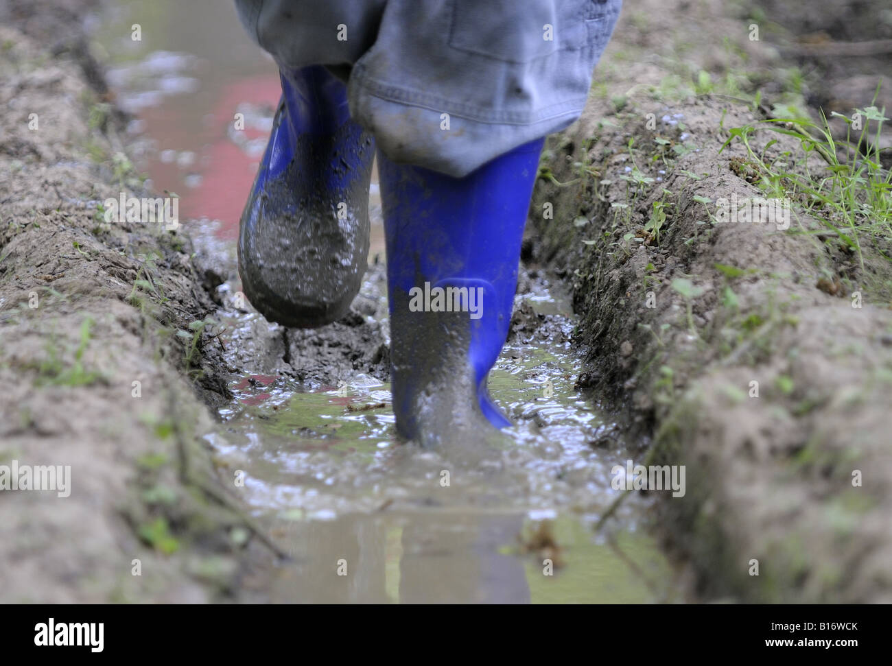 Boy in wellington boots in a muddy rut Stock Photo - Alamy
