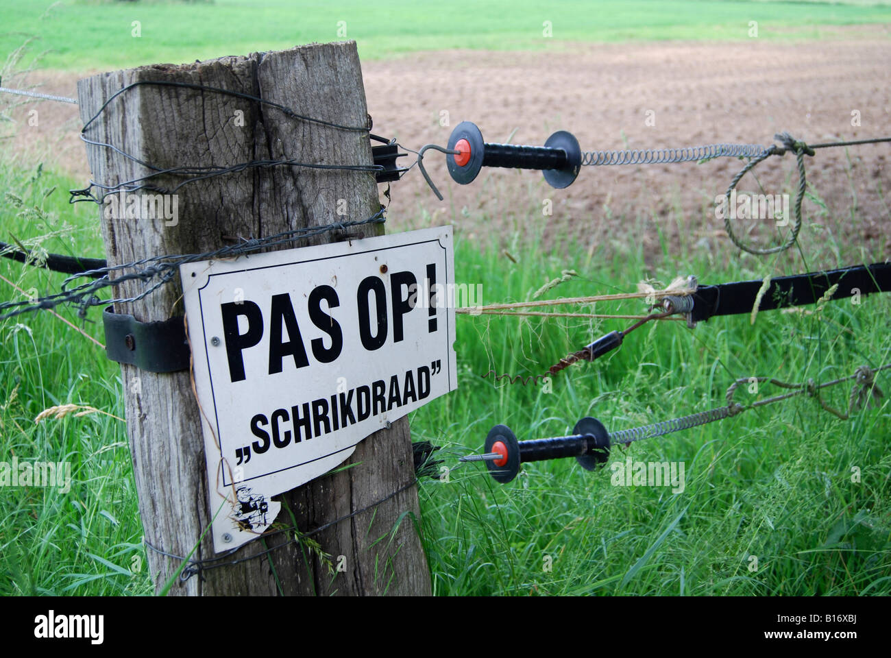 barbed wire fence with warning sign in Dutch Stock Photo - Alamy