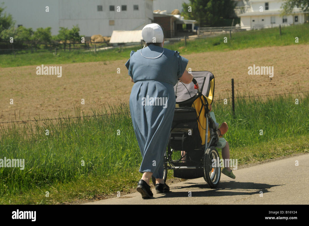 Amish lady pushing stroller along country road Stock Photo - Alamy