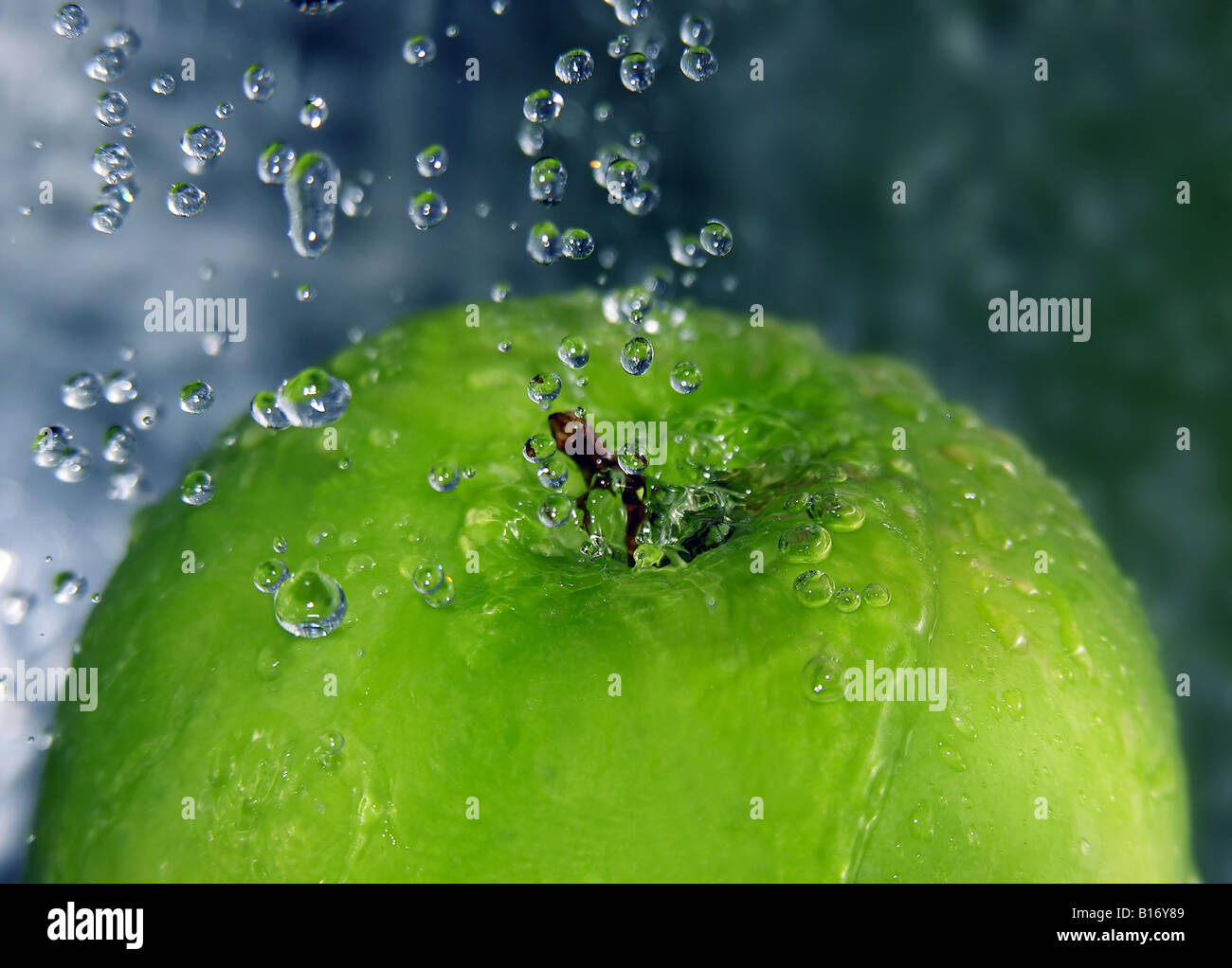 Water drops falling onto a green apple Stock Photo - Alamy