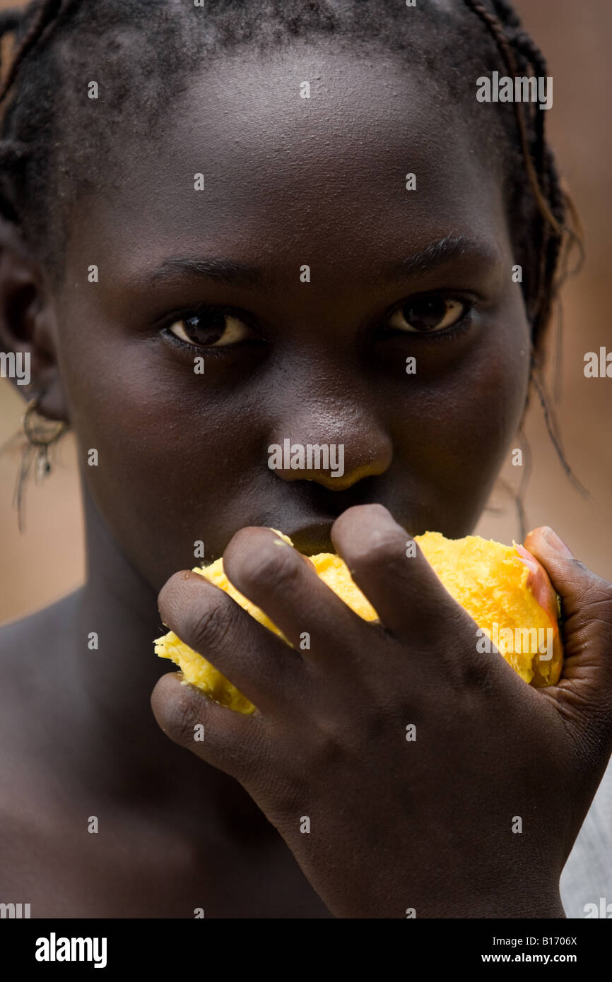 A girl eats a mango Stock Photo - Alamy