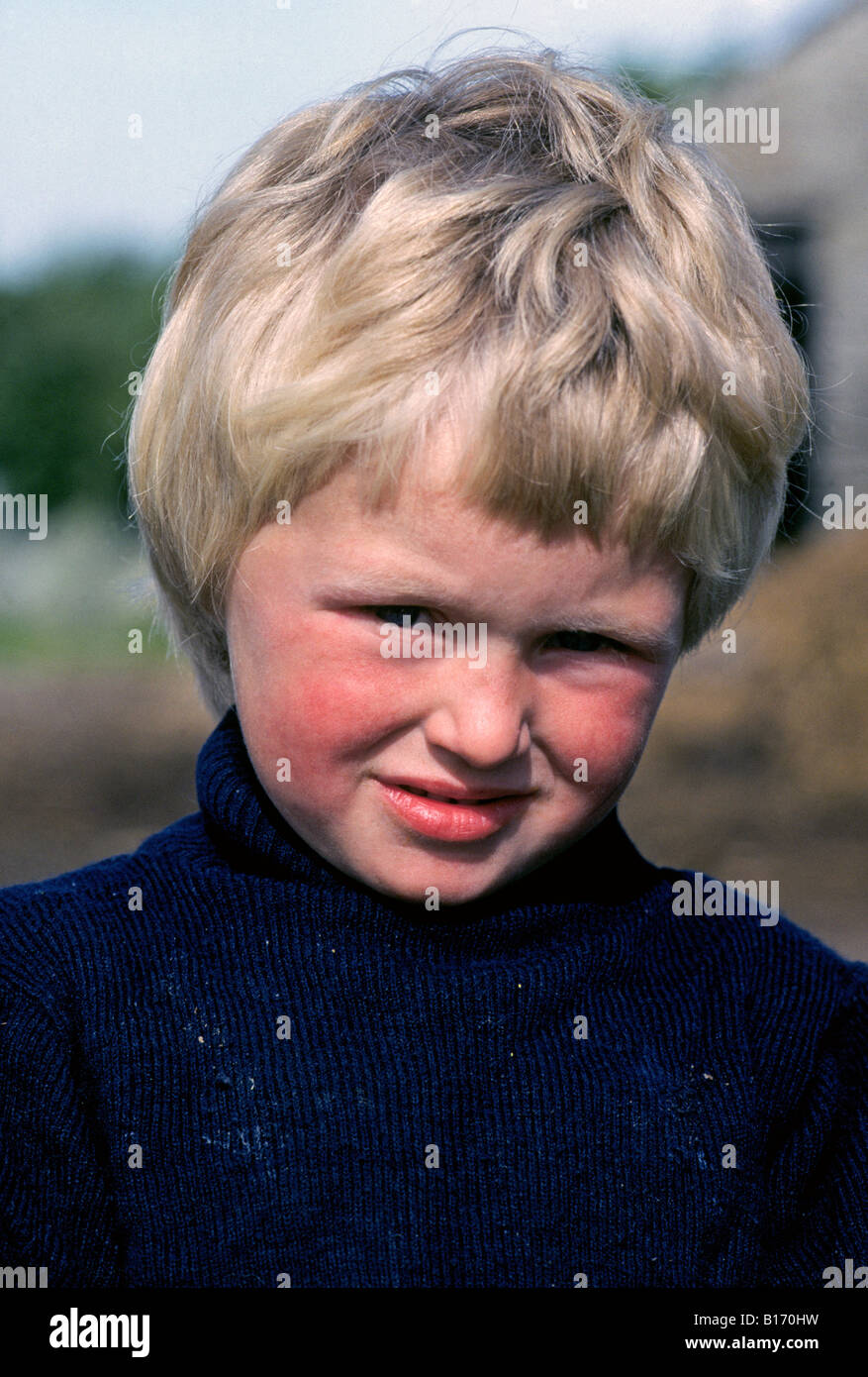 A young farm boy with rosy cheeks on a farm along the Cornwall Coast ...