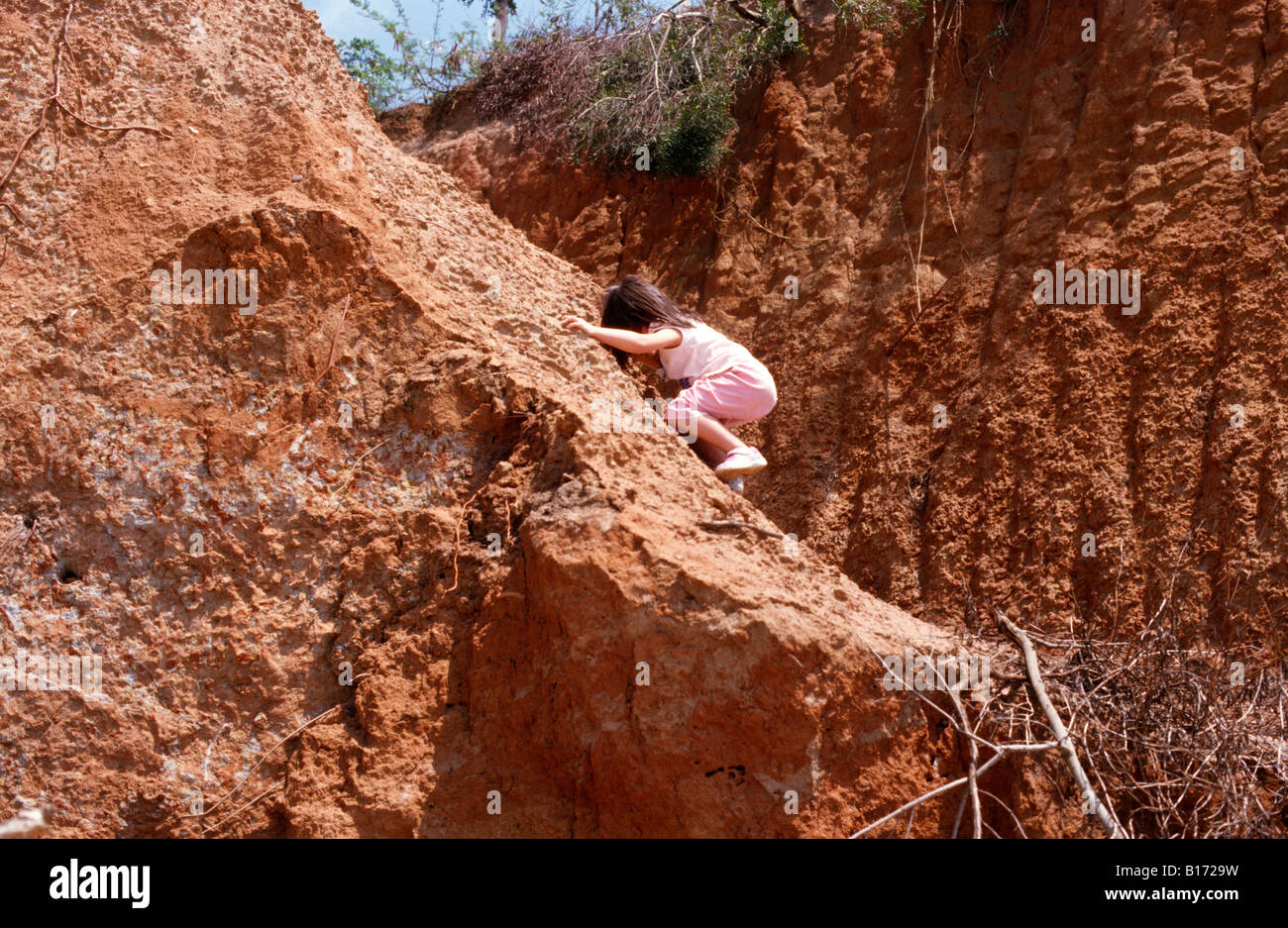 Four year old girl climbing down a hill Stock Photo - Alamy
