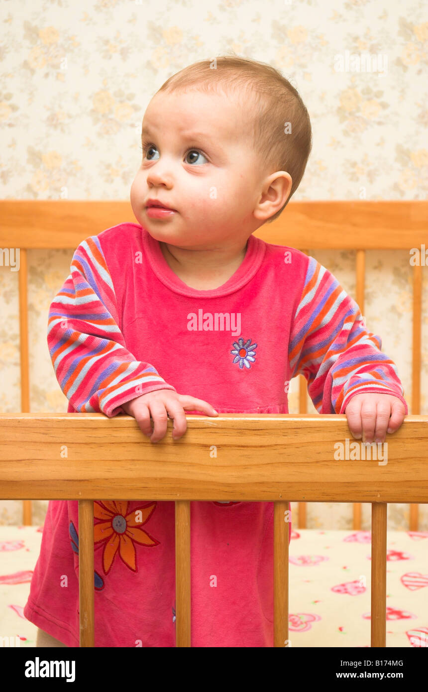 A cute toddler standing up in her cot Stock Photo - Alamy