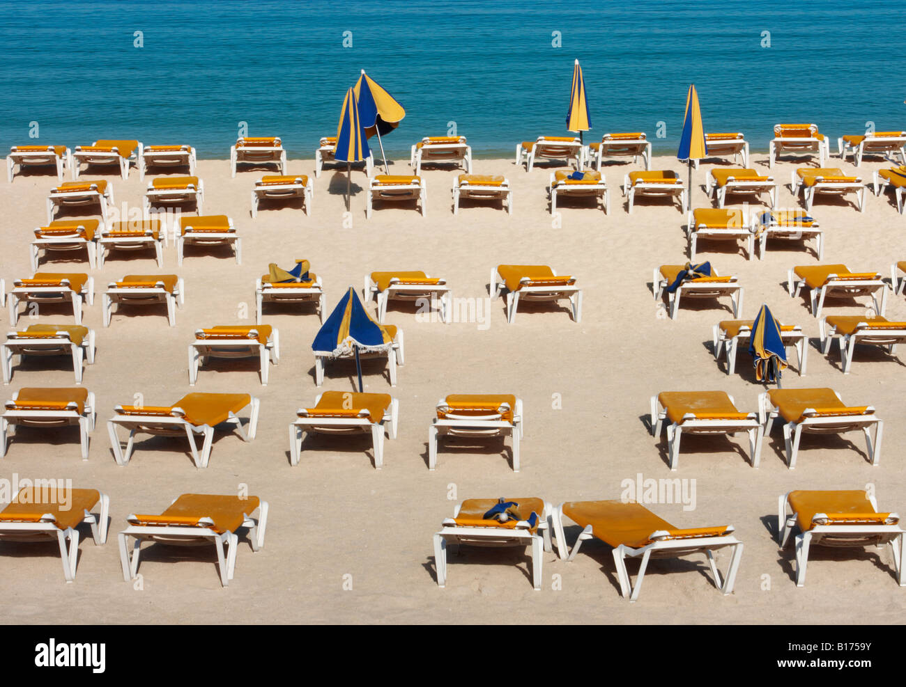 Sunbeds on empty beach in Spain Stock Photo - Alamy