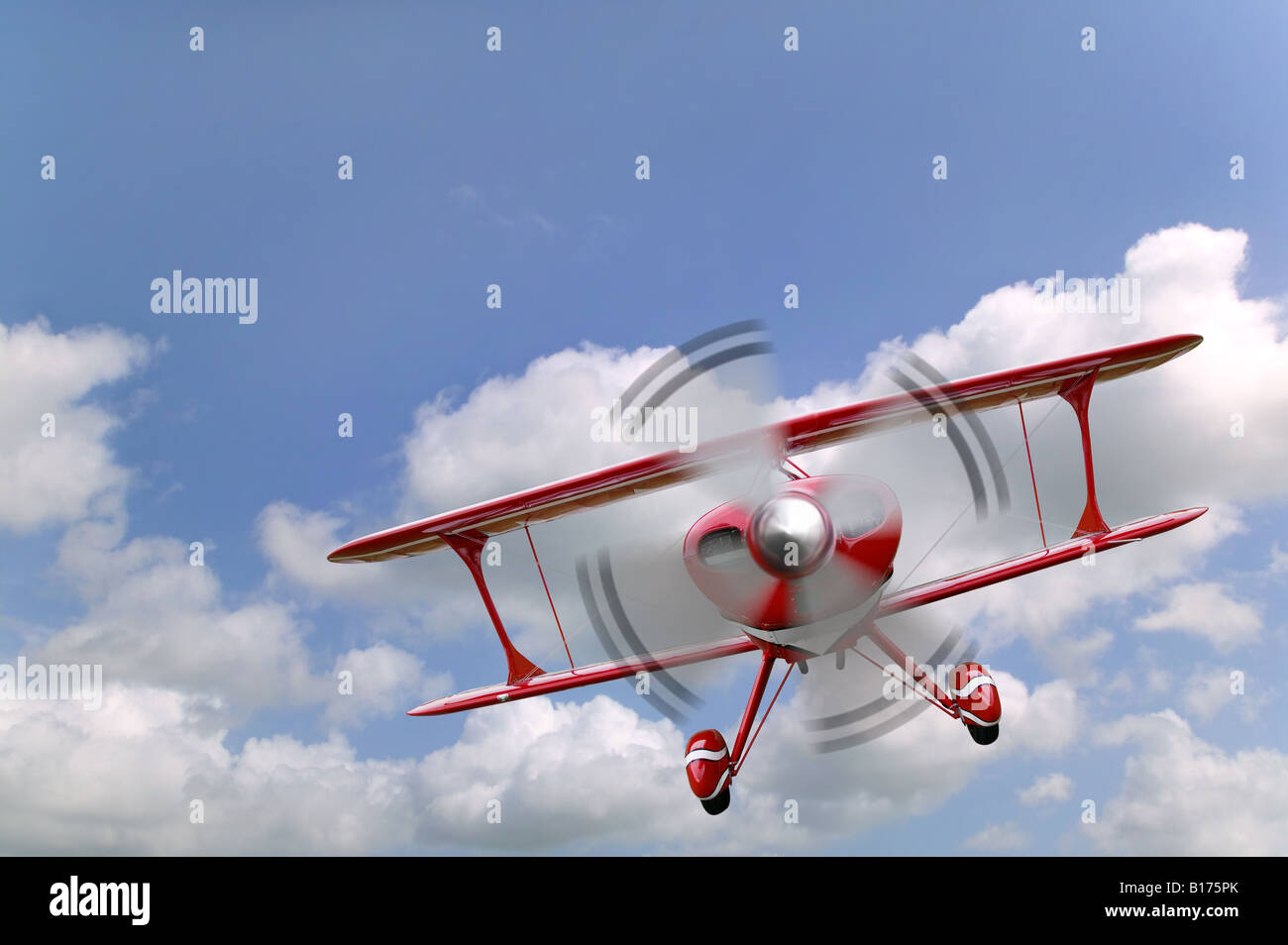 A red biplane flying in a blue cloudy sky Stock Photo - Alamy