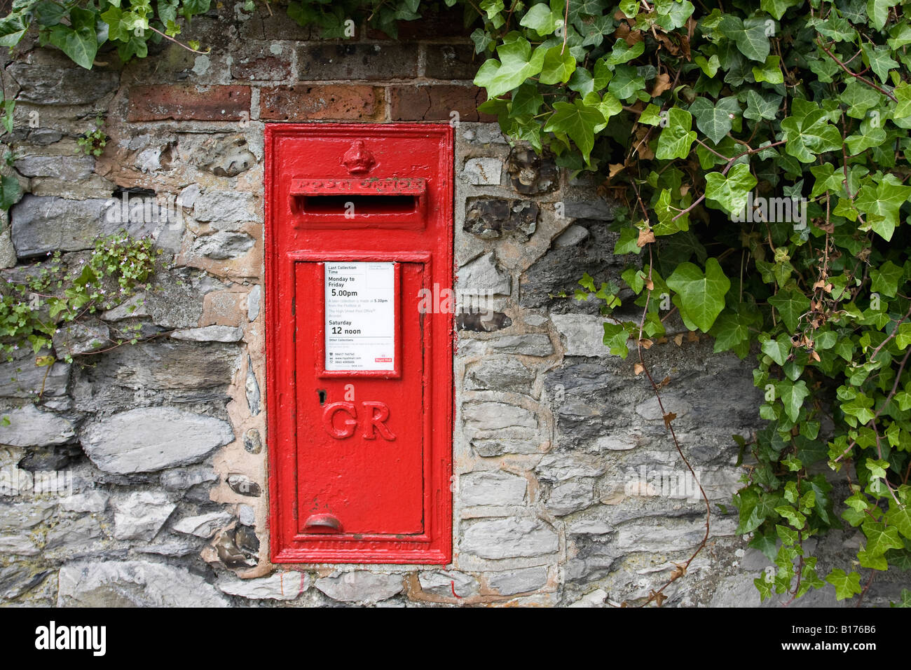 Red post box set into wall. Sussex, England, UK Stock Photo - Alamy