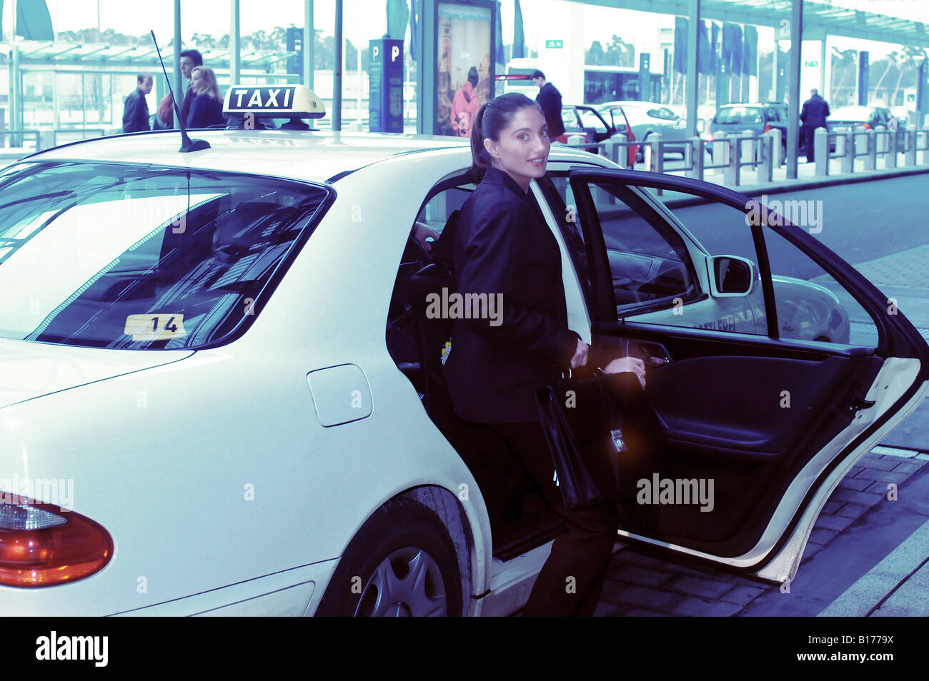 businesswoman leaving a taxi at airport Stock Photo - Alamy