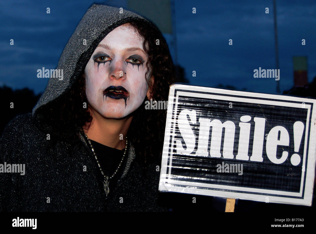 A 'Goth' holds up an ironic sign reading 'Smile' at the Lost Vagueness ...