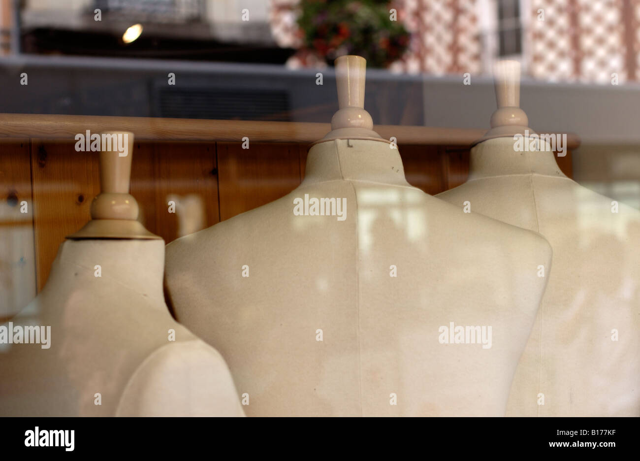 Three tailors dummies in shop window Stock Photo - Alamy
