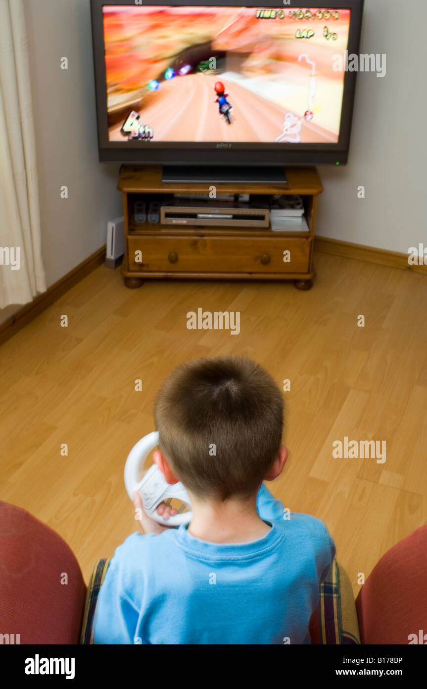 Boy Playing With Nintendo Wii Wheel And The Game Mariokart Stock Photo ...