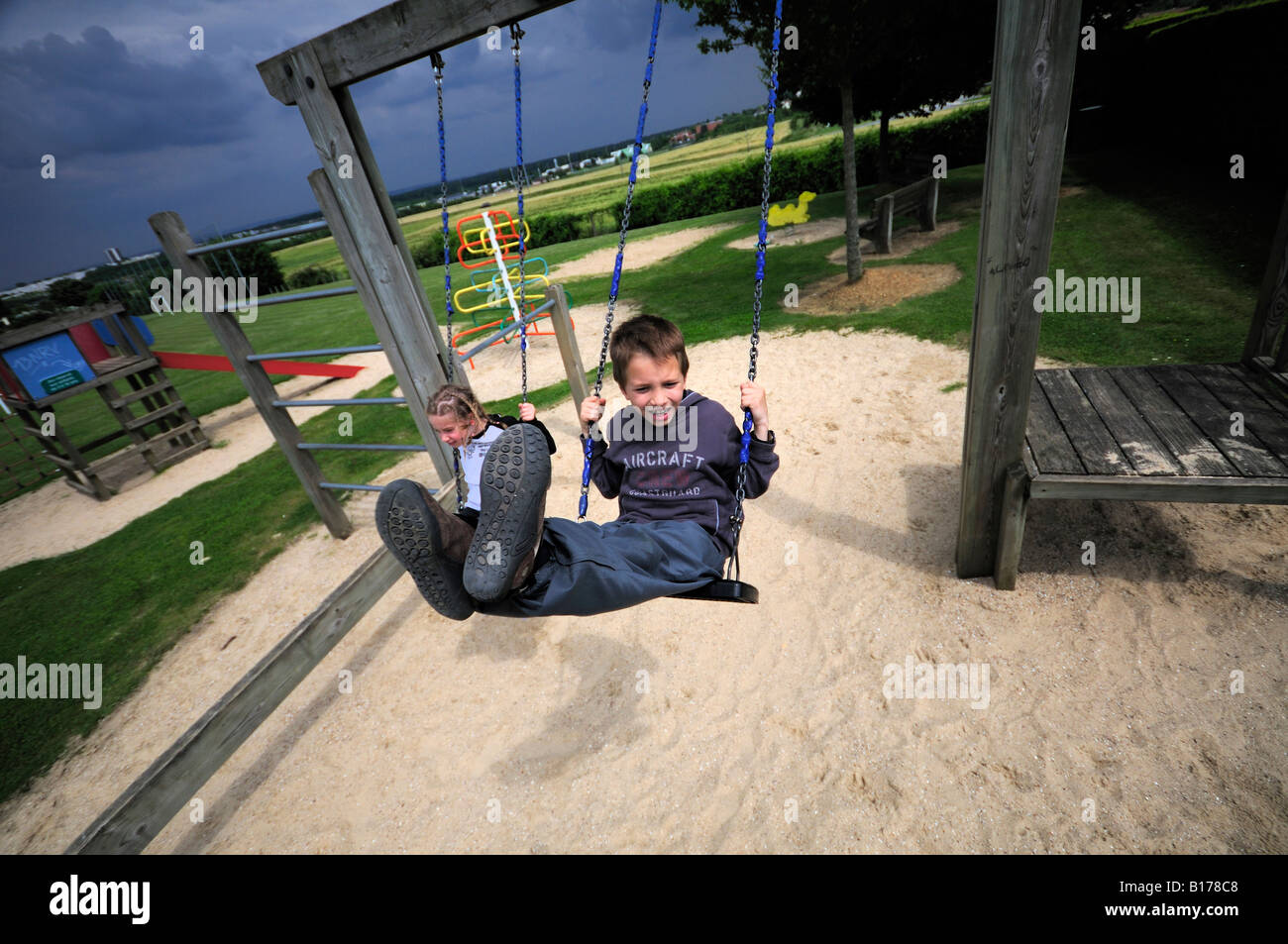 Boy and girl on a swing teeter playground in move Stock Photo - Alamy