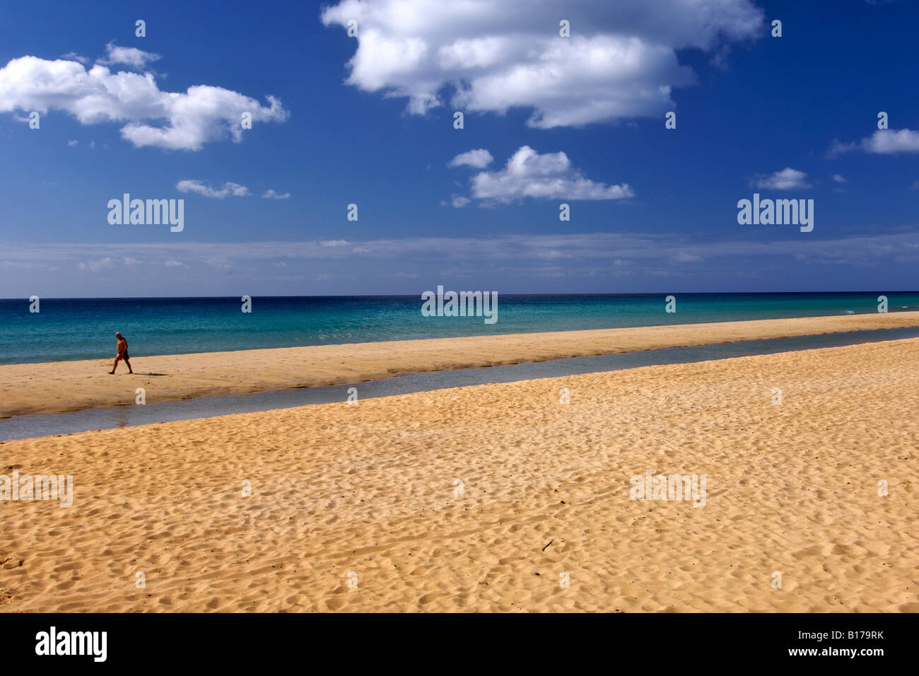 A man walking along the beach of the Portuguese Atlantic island of ...
