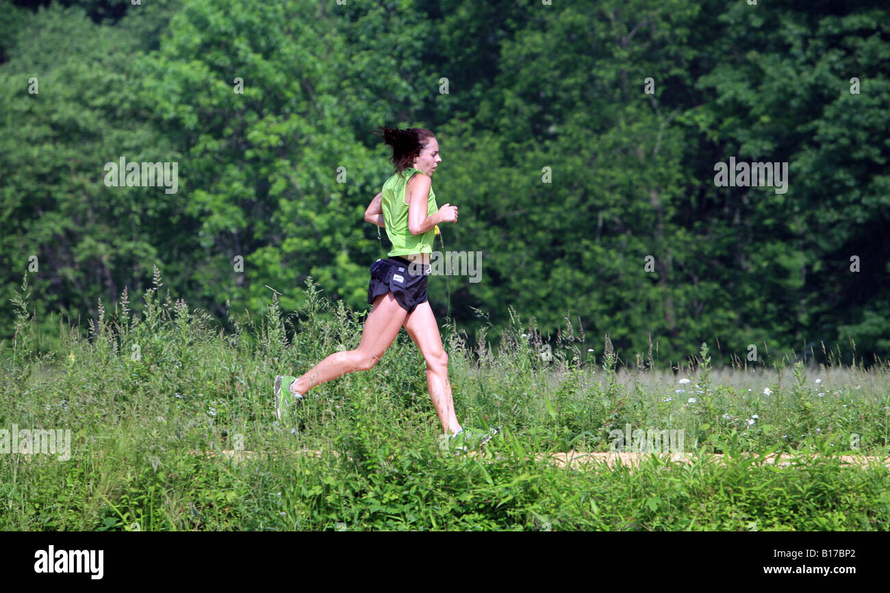 A lone female runner jogging a through the forest Stock Photo - Alamy