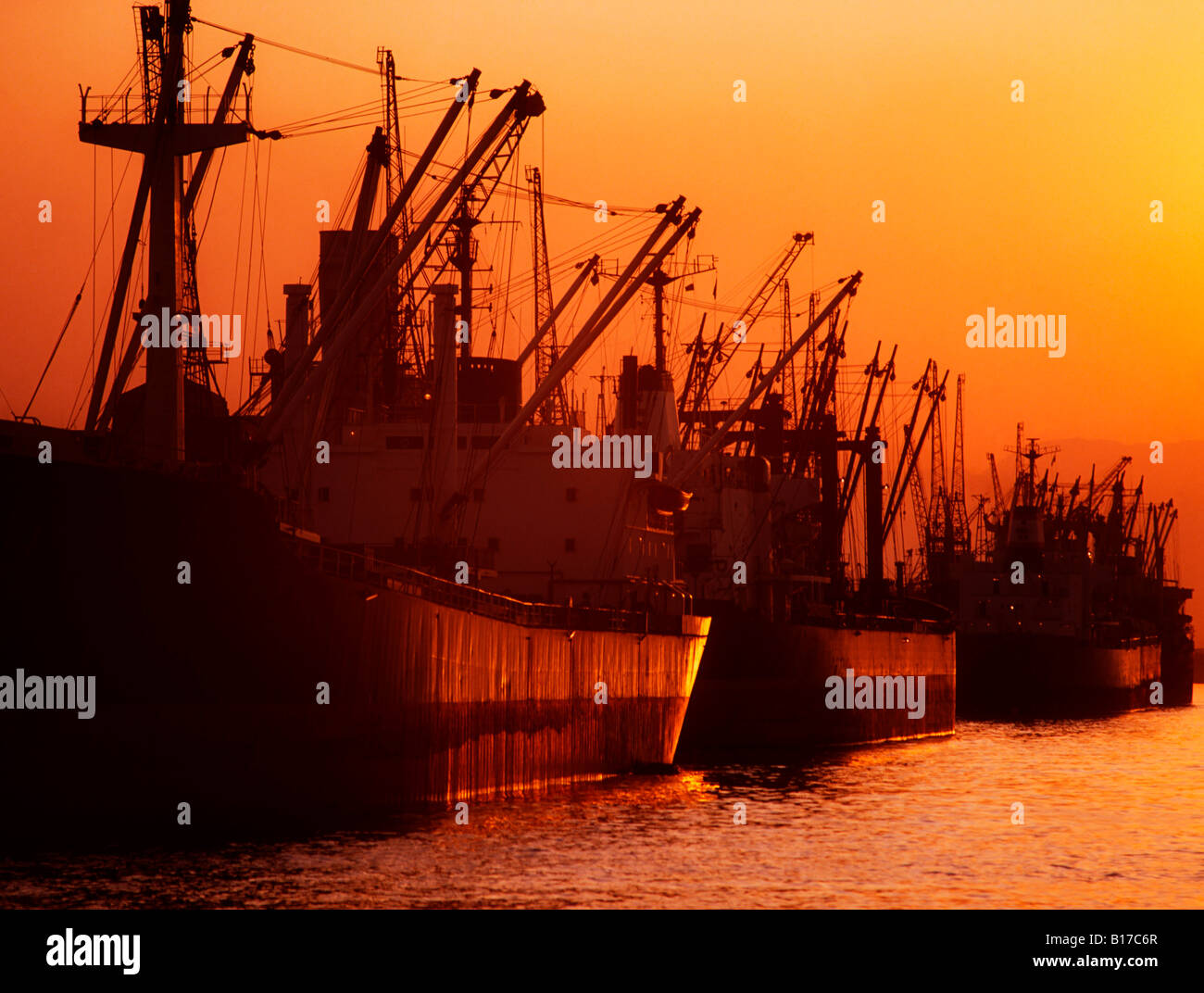 Shipping freighters at sunset Stock Photo - Alamy