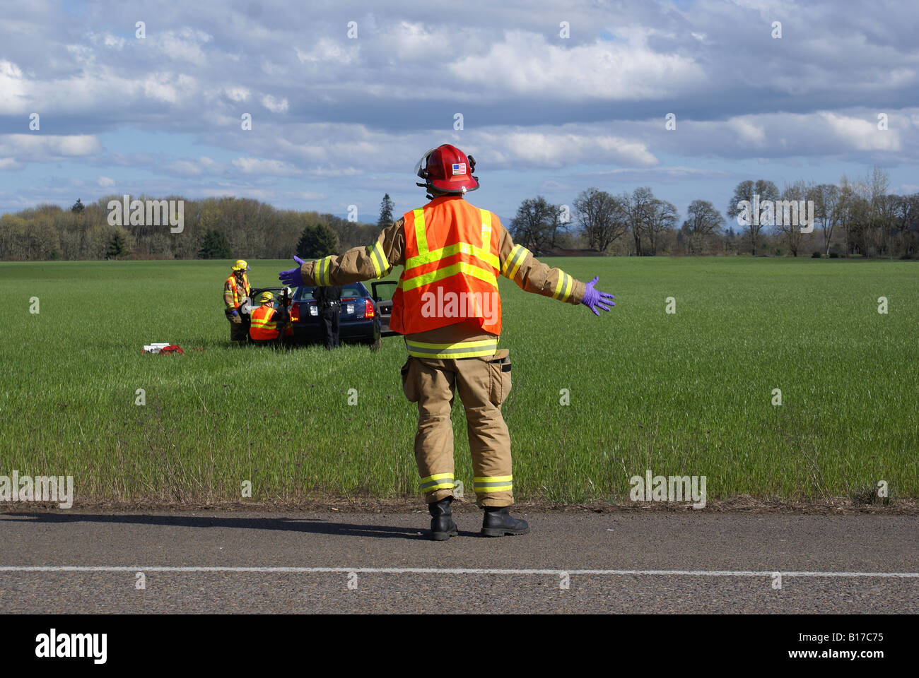 Fireman directing traffic at crash site Stock Photo - Alamy