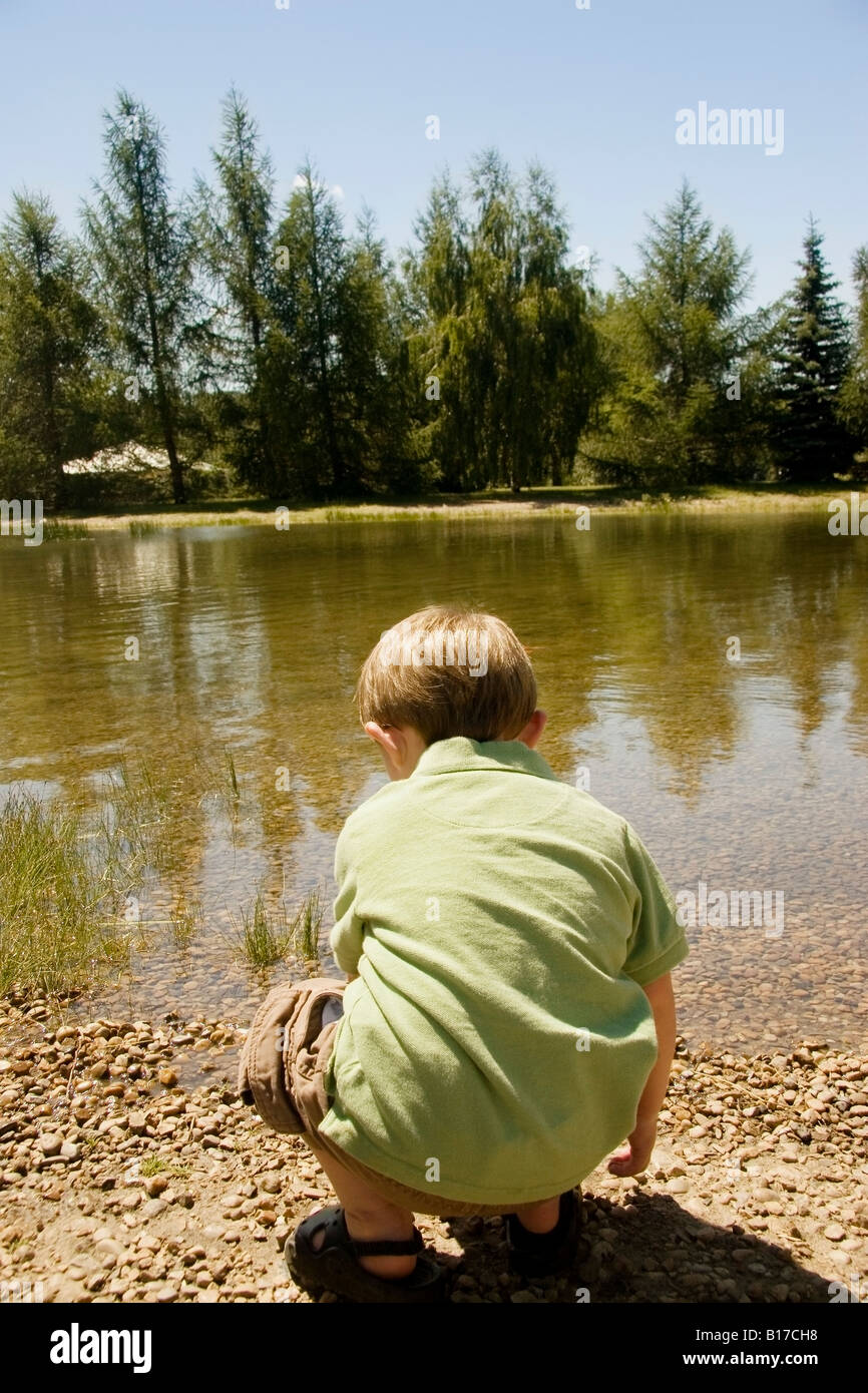 Boy beside stream Stock Photo - Alamy