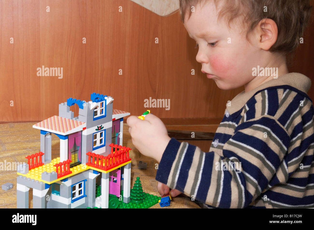 Small boy play with building set for children (built a house Stock ...