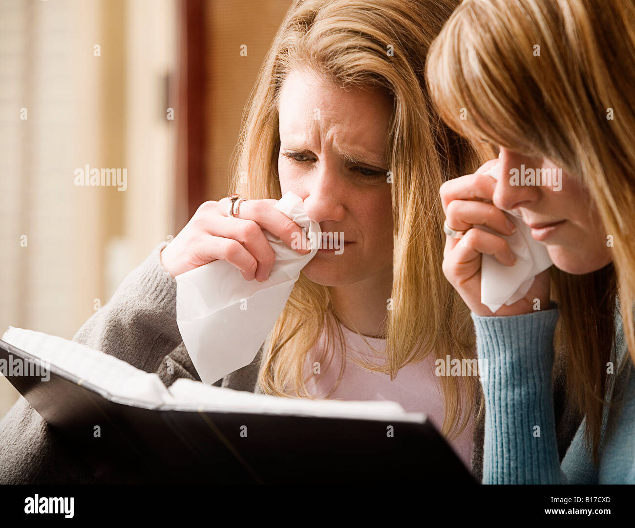 Women crying while looking at photo album Stock Photo - Alamy