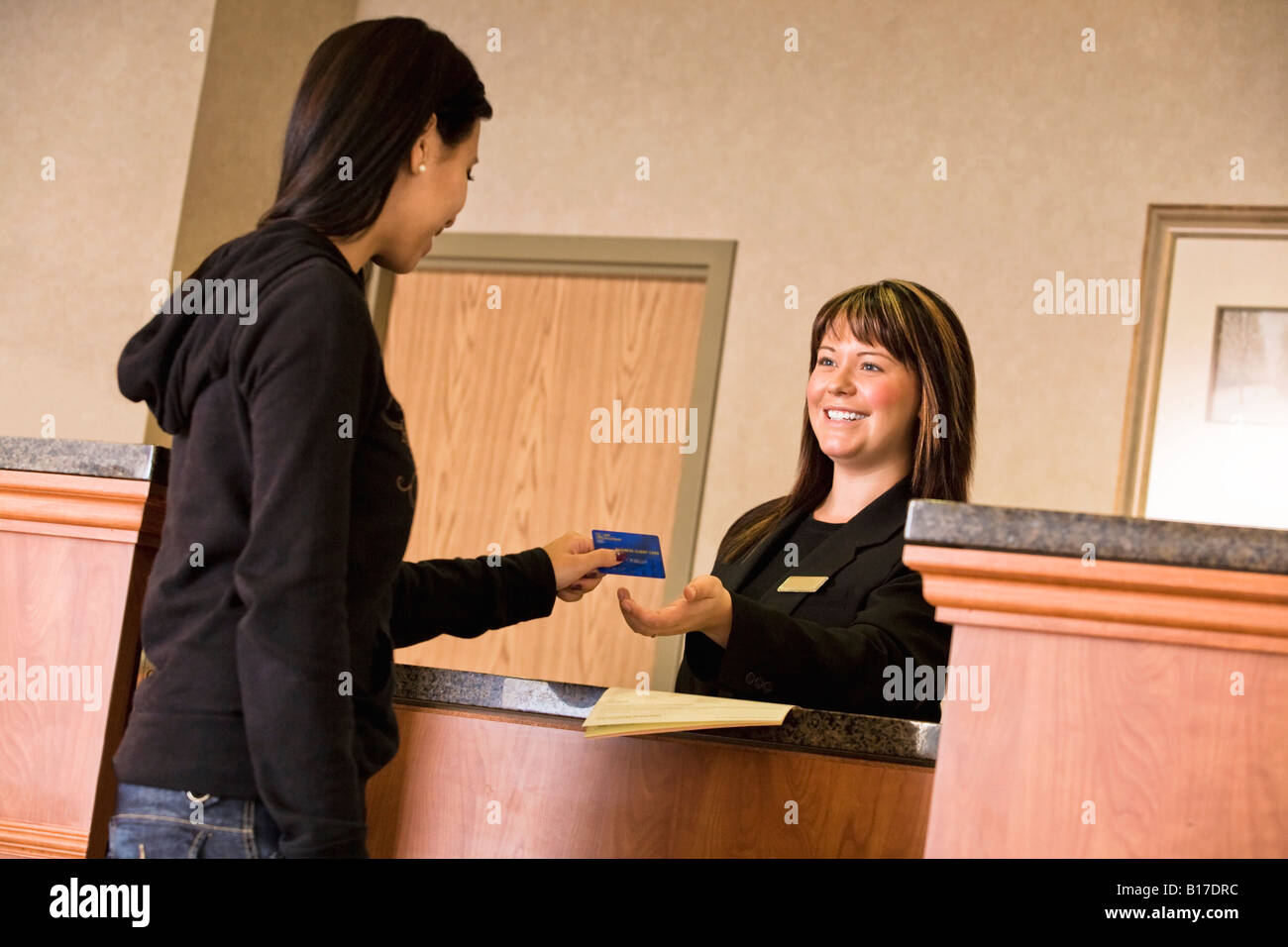 Woman checking in at hotel lobby Stock Photo - Alamy