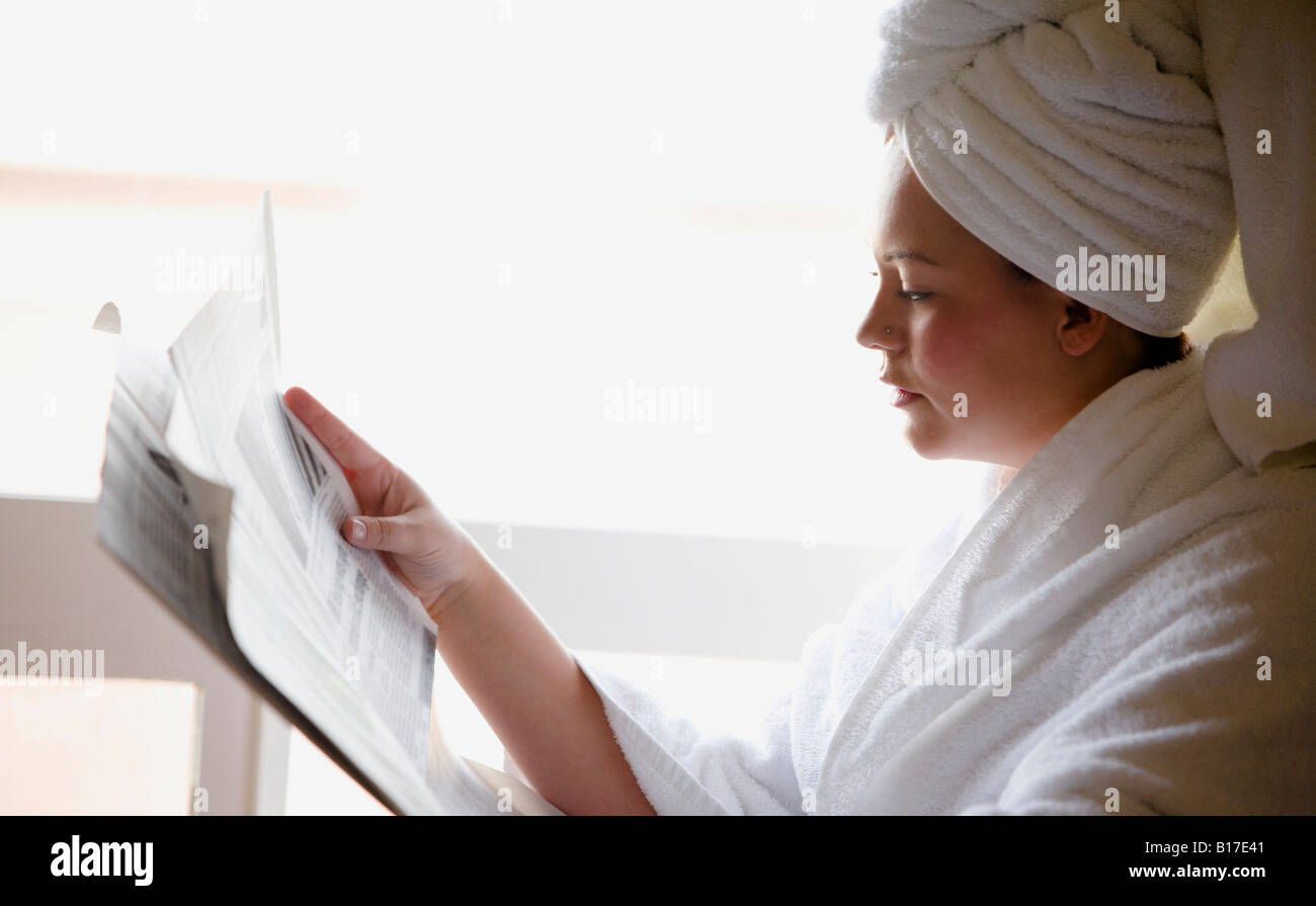 Woman reading newspaper in robe and towel Stock Photo - Alamy