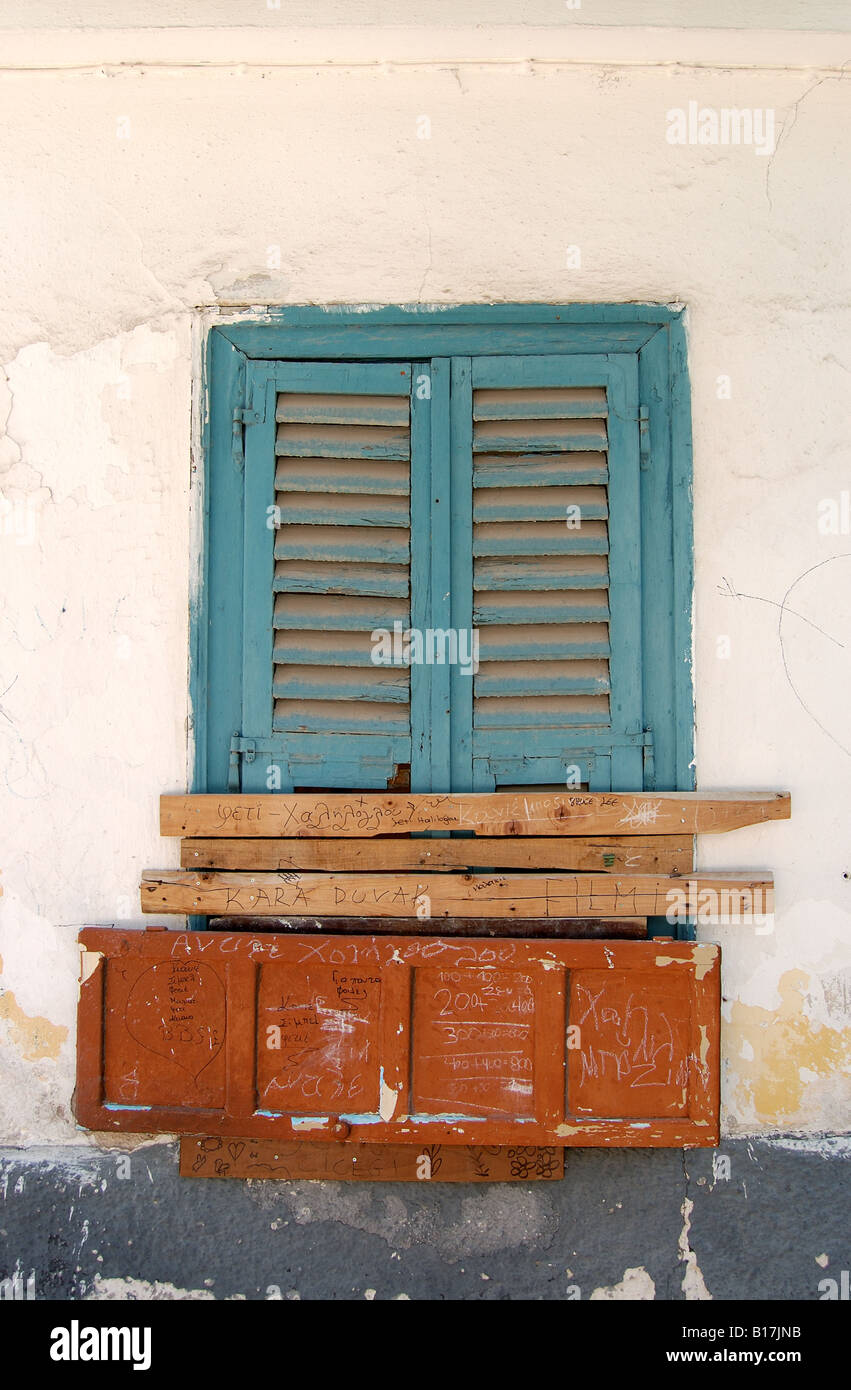 Boarded up old window with blue shutter and peeling paint weathered ...