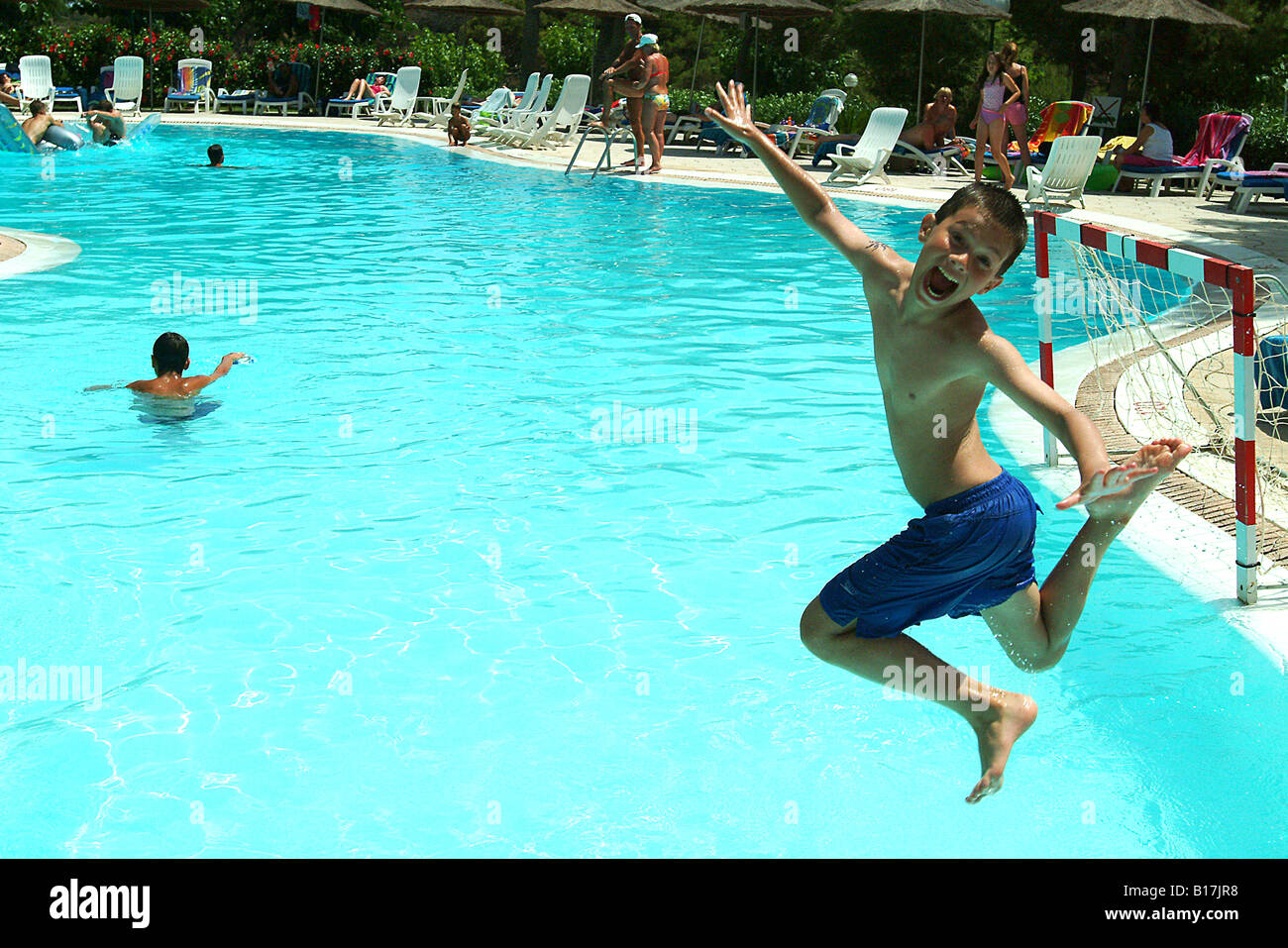 Young boy jumping into swimming pool on Mediterranean holiday Stock ...
