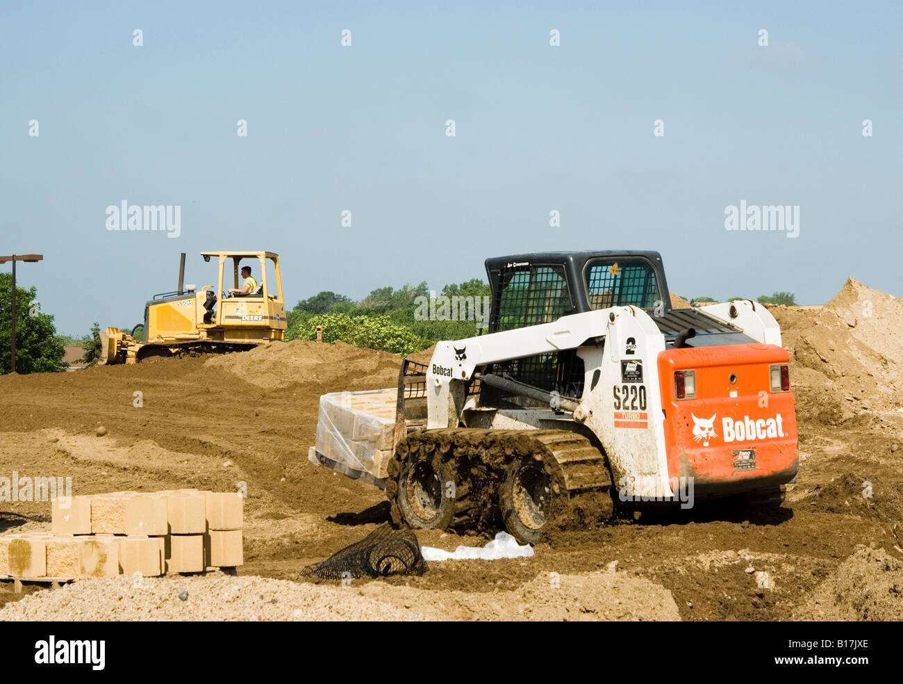 a bobcat skid loader at work on a consturction site Stock Photo - Alamy