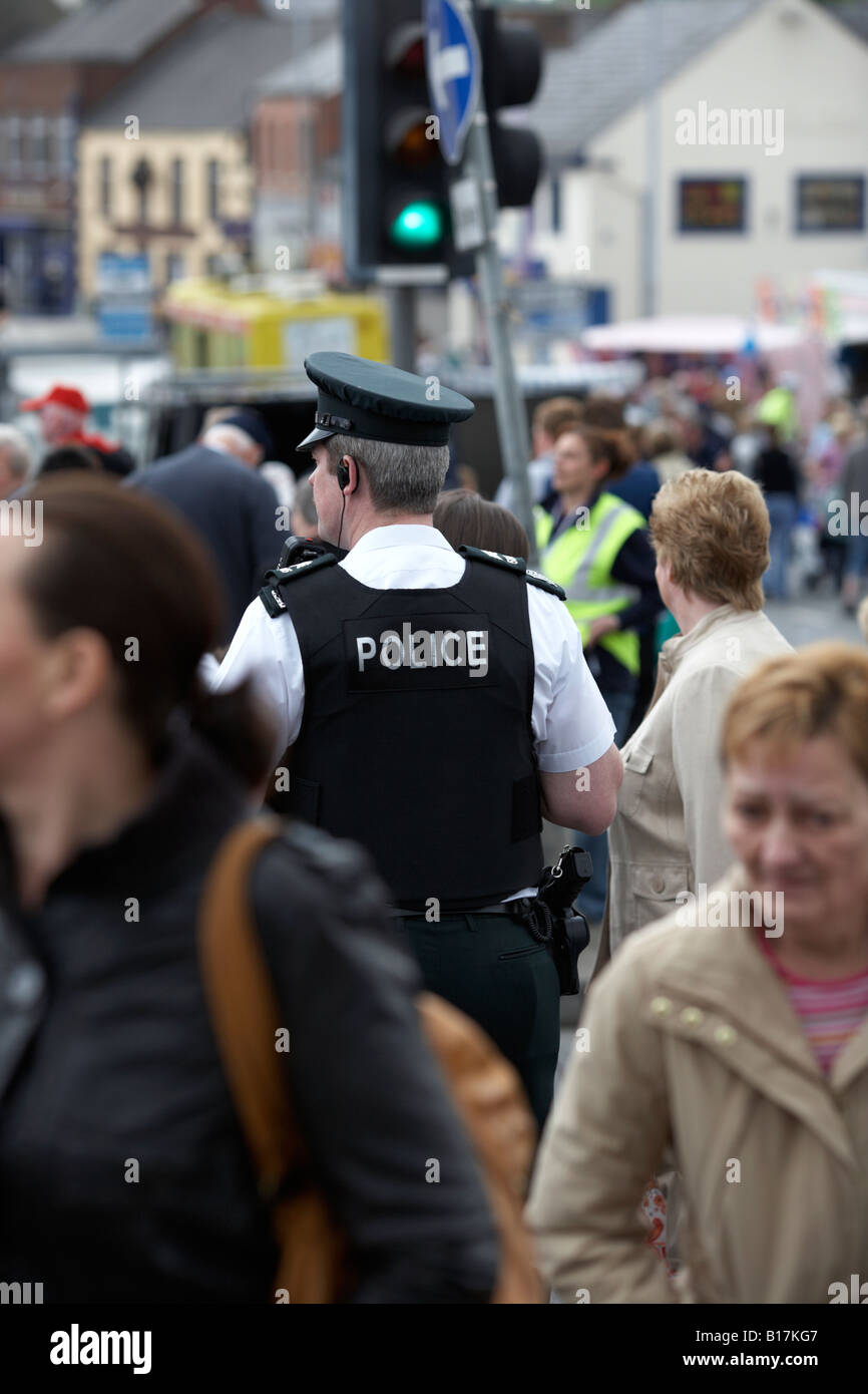 armed psni police officer on the beat patrolling crowd at the ...