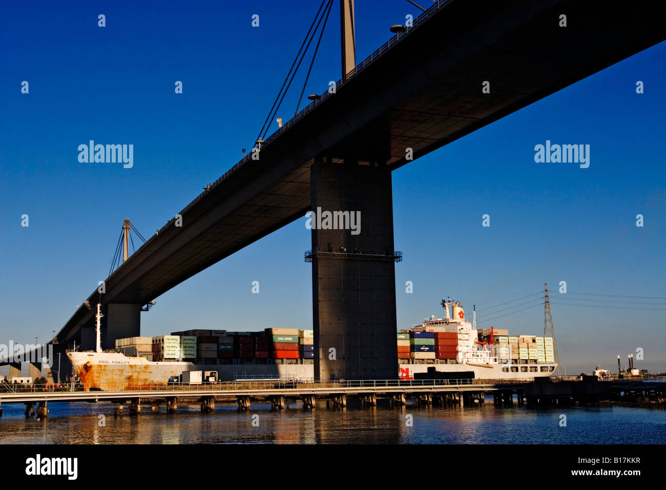 Shipping Industry / A Container Ship passing under a Bridge Stock Photo ...