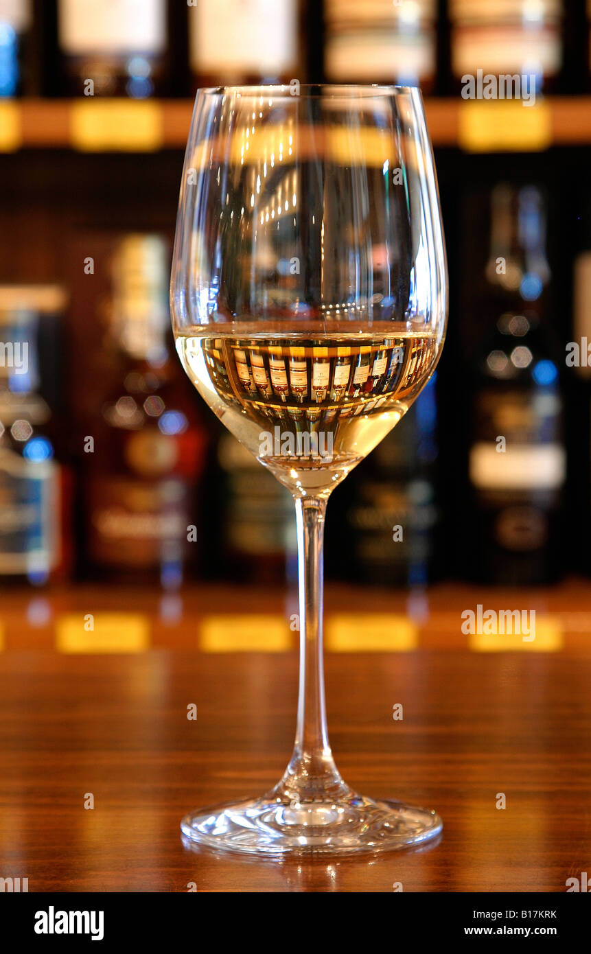 a glass of wine with reflection of bottles Stock Photo - Alamy