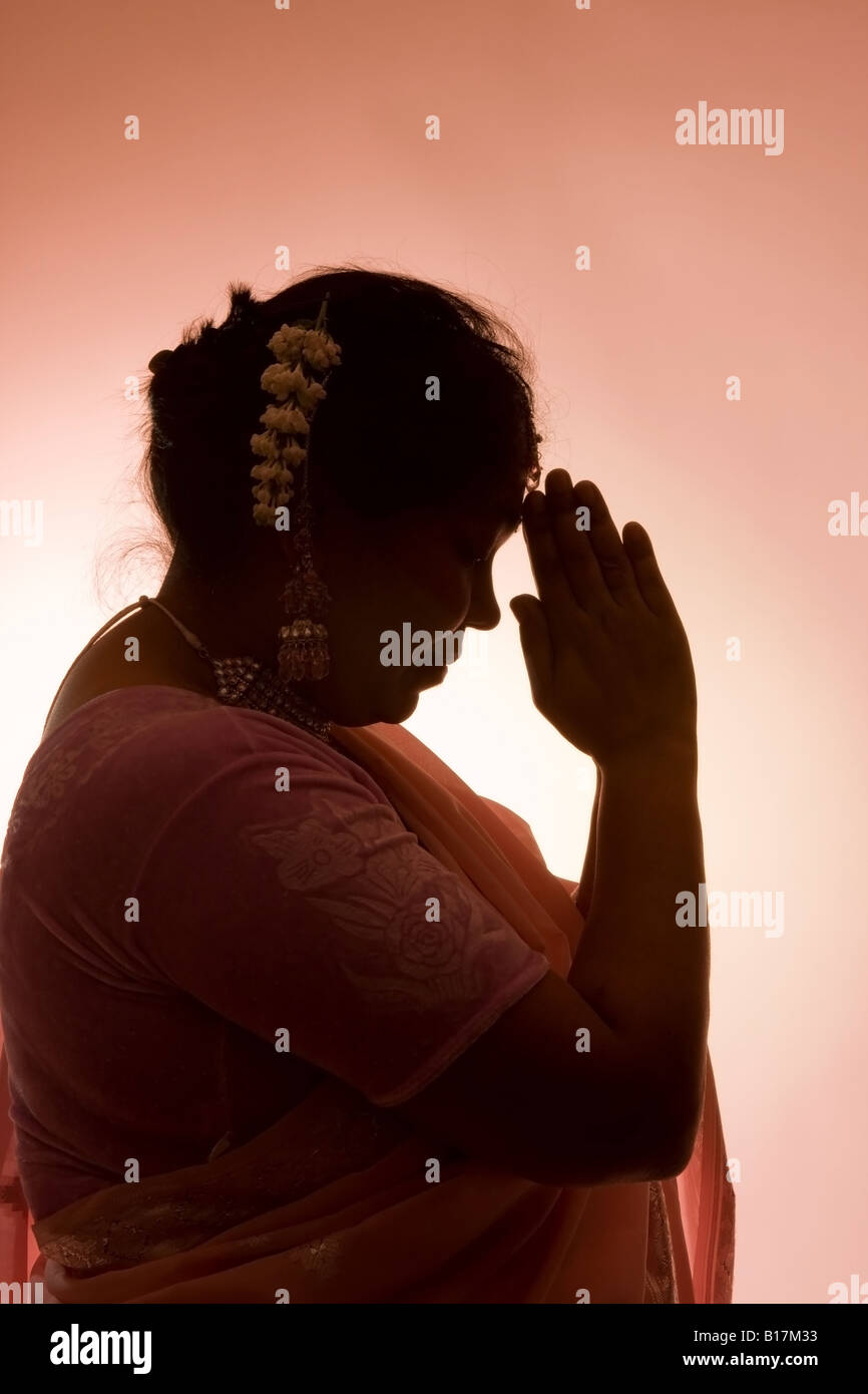Indian woman in saree saying her prayers at sunset Stock Photo - Alamy
