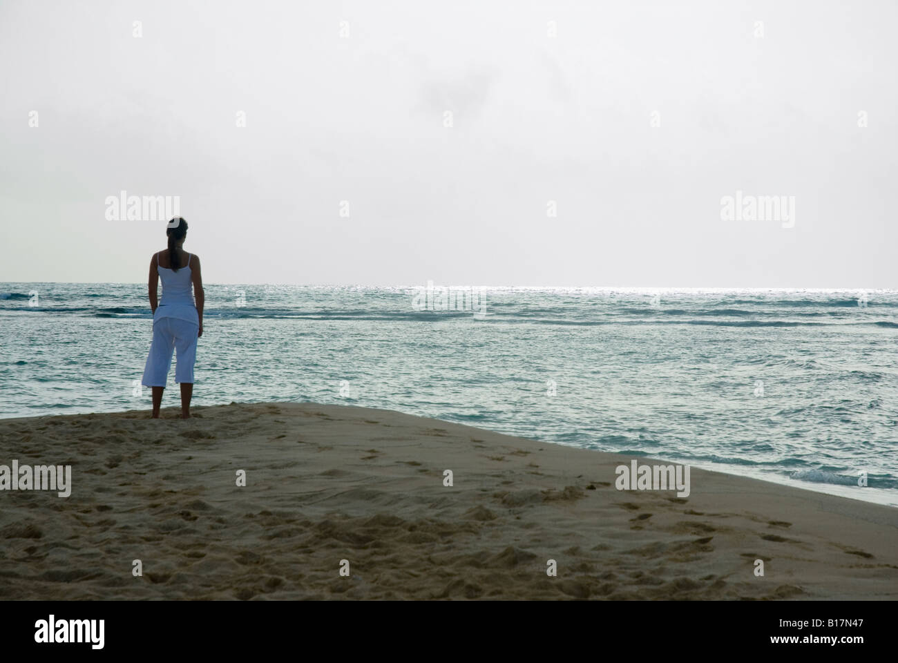 Woman looking out over ocean Stock Photo - Alamy