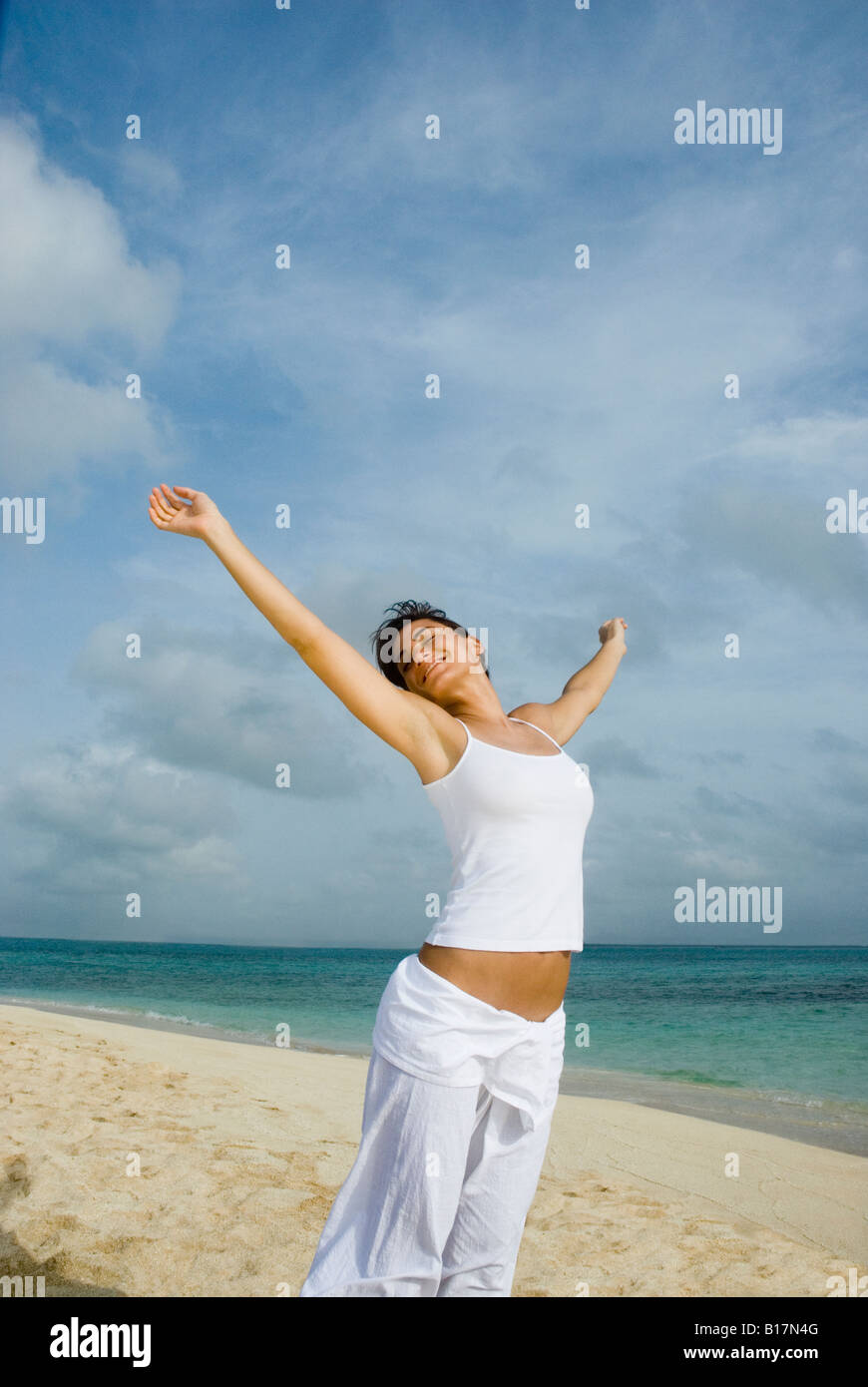 Woman with arms raised at beach Stock Photo - Alamy