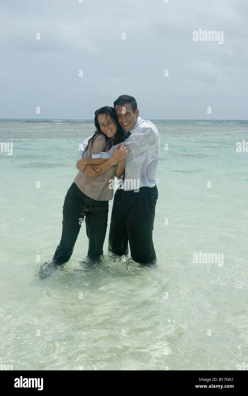 Hispanic businesspeople hugging in water Stock Photo - Alamy