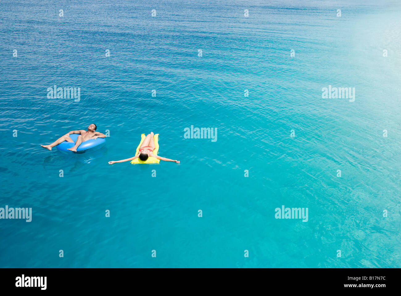 Multi-ethnic couple on floats in water Stock Photo - Alamy