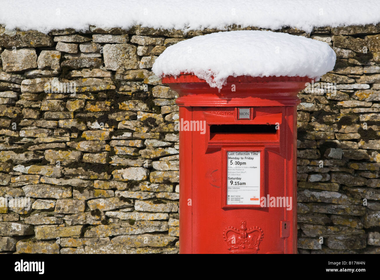 red Royal Mail post box in snow by drystone wall Oxfordshire England UK ...