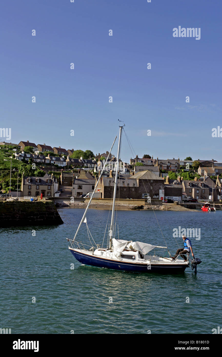 sailing boat enters the harbour at the small coastal village of Gourdon ...