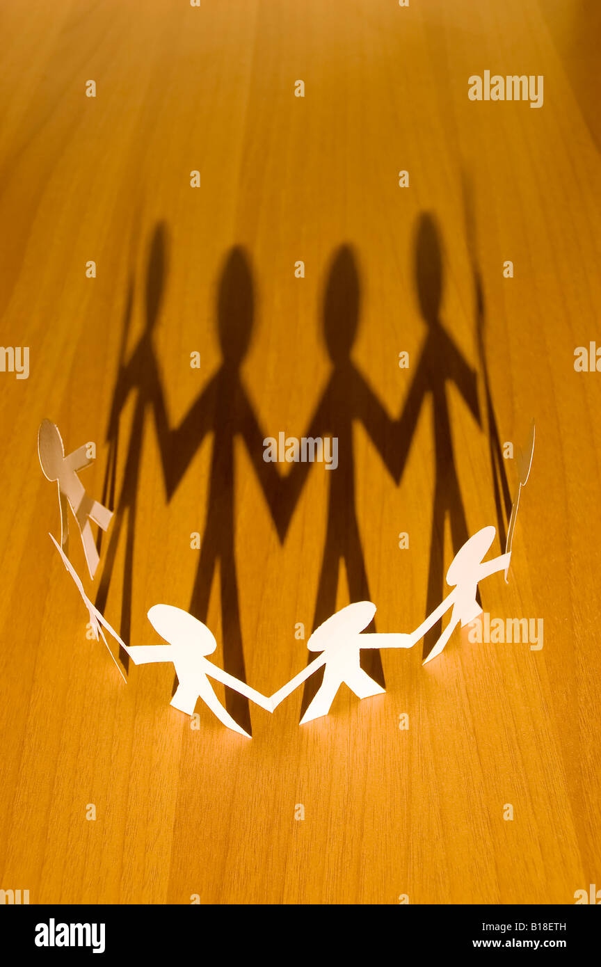 Paper man chain with long shadow on wooden table Symbol of unity ...
