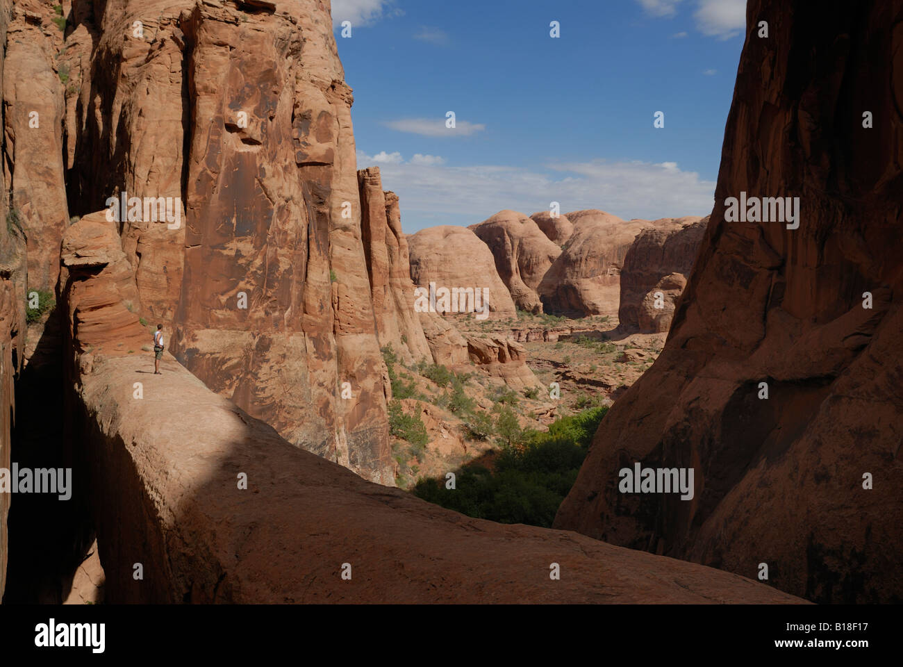 Man admiring the stunnning scenery standing on a giant arch on the ...