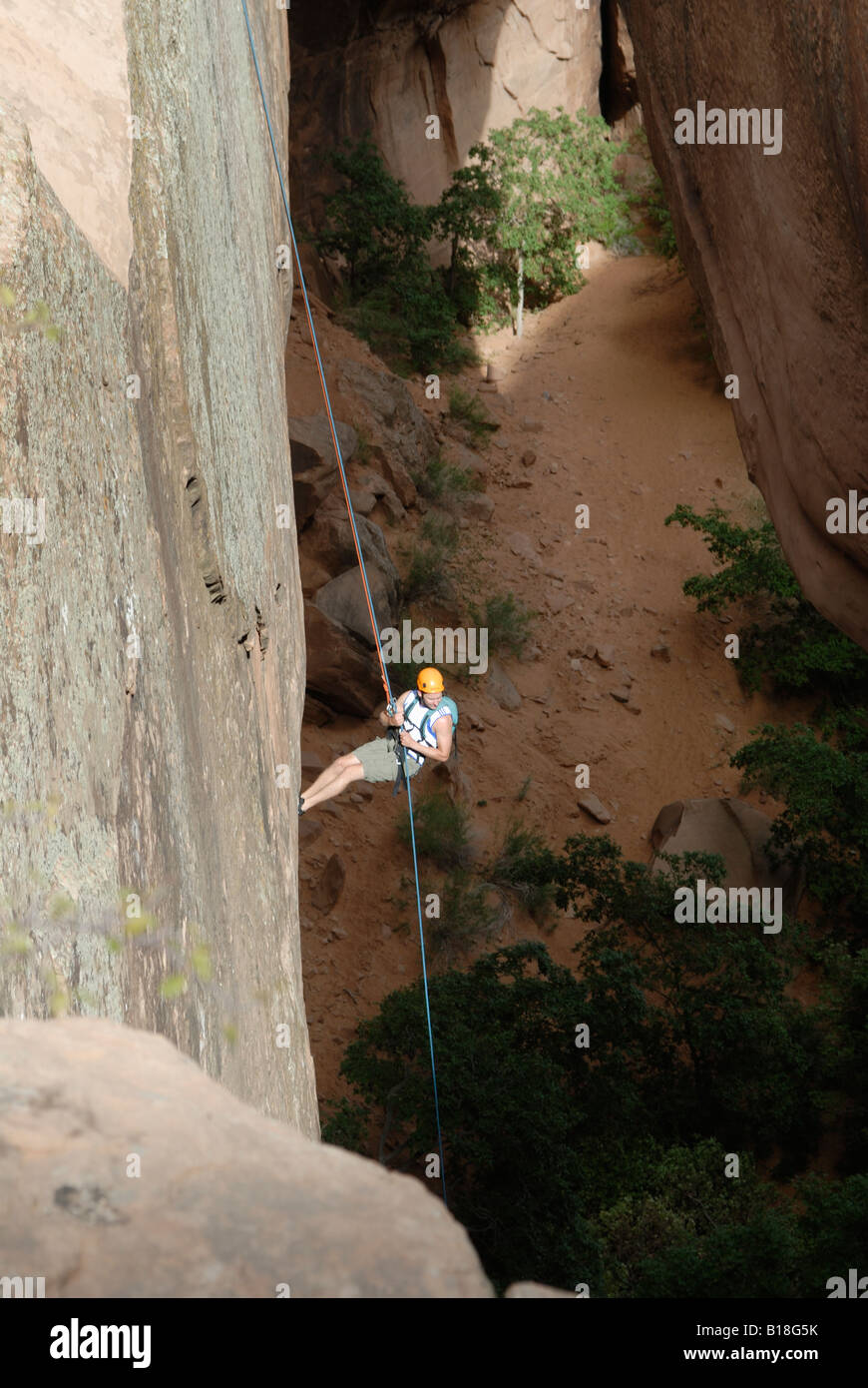 Tourist hanging on a rope while Canyoning in the area of the slick rock ...