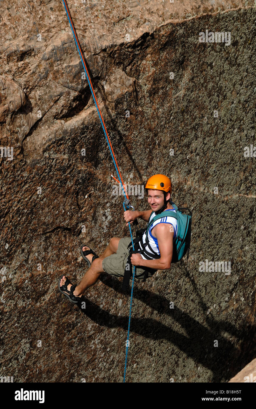Tourist hanging on a rope while Canyoning in the area of the slick rock ...