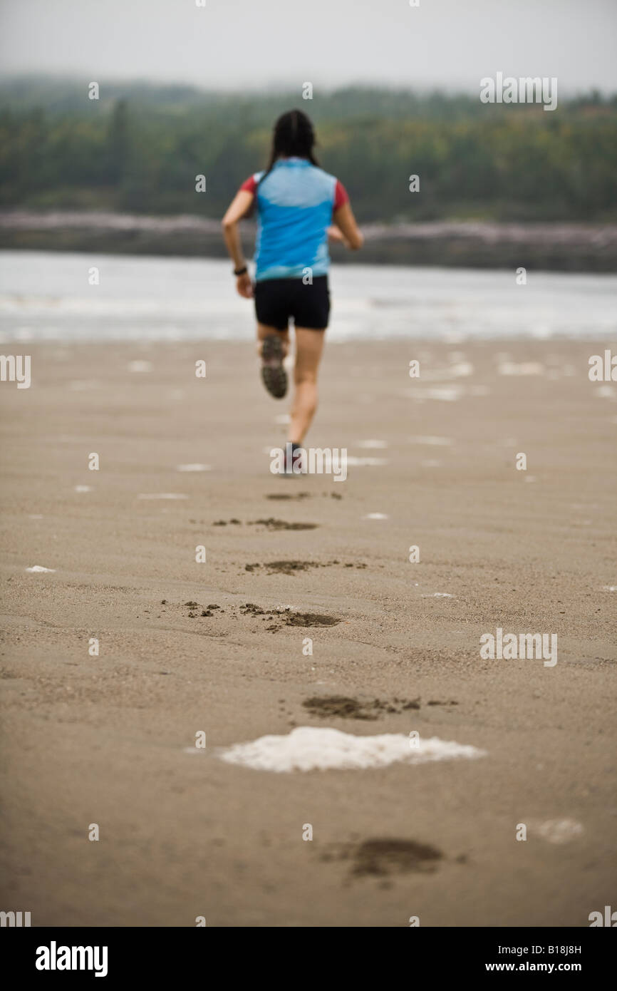 A young female running along the shores of the beach at Mispec Park ...