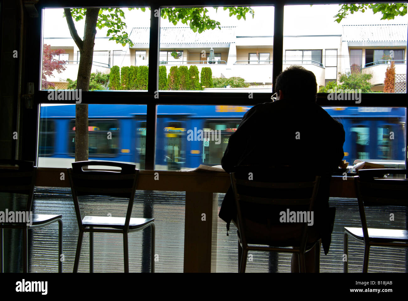 Patron having a leisurely lunch at a street window bar of a fast food ...