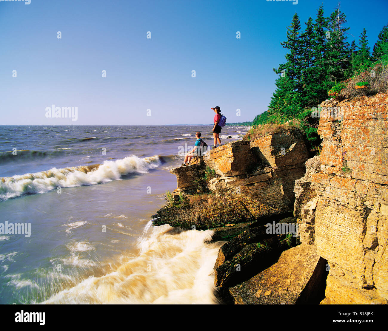 couple on sedimentary rock cliff, Hecla Provincial Park, Manitoba ...