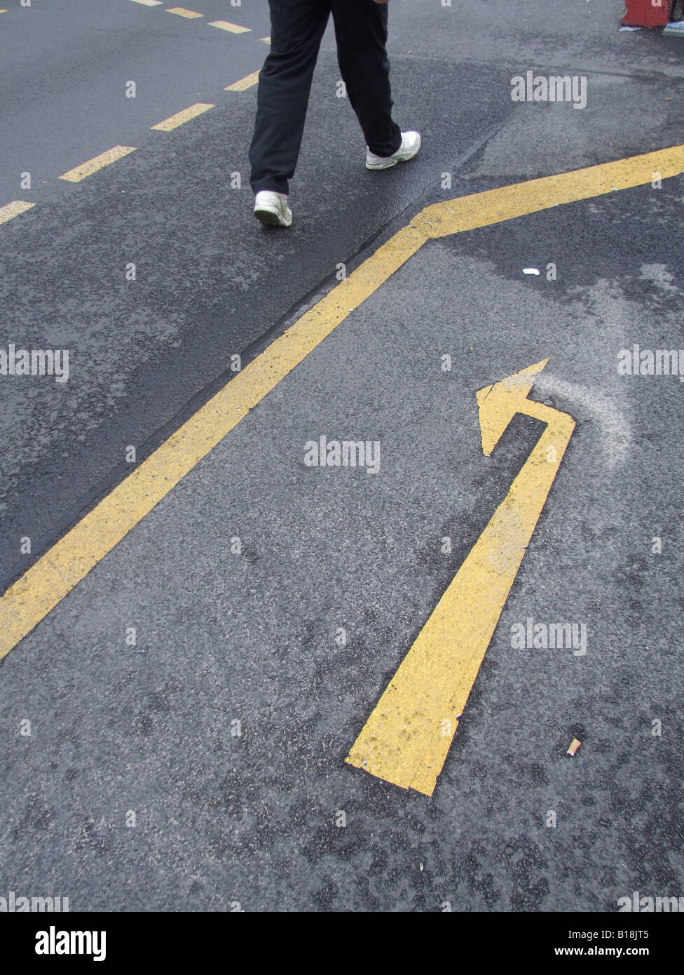 yellow arrow road markings on street road in city town Stock Photo - Alamy