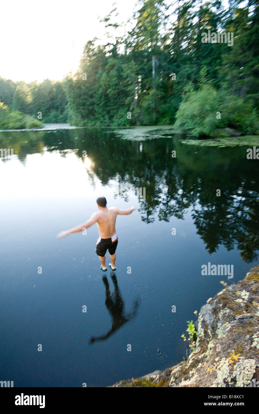 A man jumps off a cliff into Thetis Lake near Victoria, British ...
