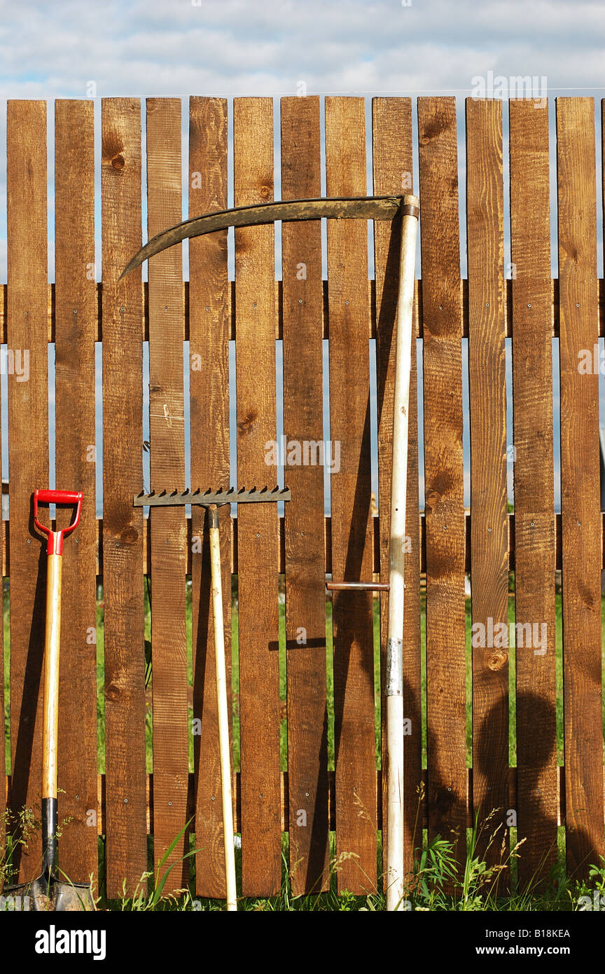 garden tool set over wood backyard fence Stock Photo - Alamy